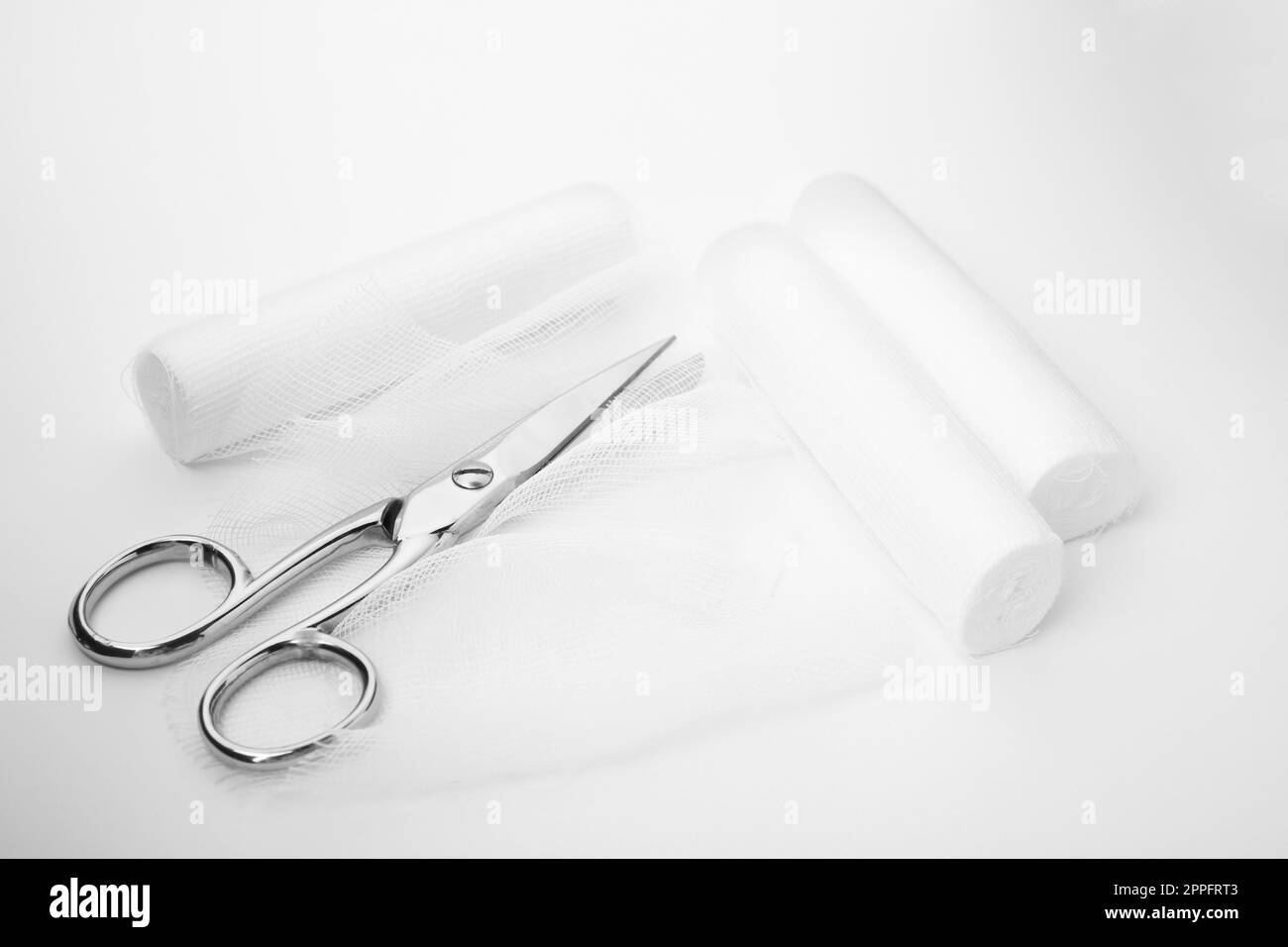 Medical bandage rolls and scissors on white background Stock Photo - Alamy