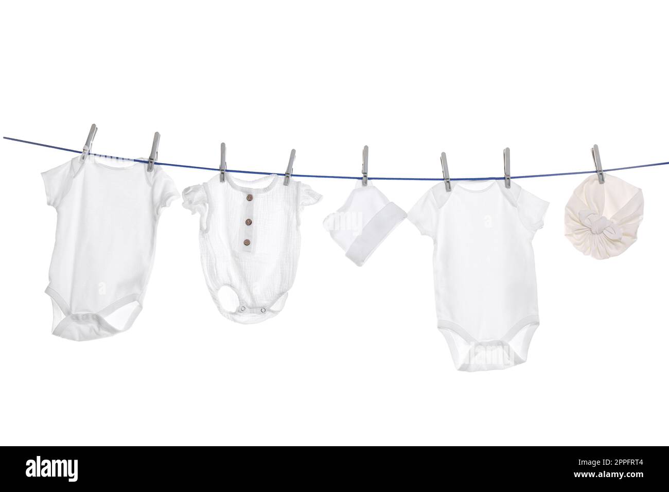 Different baby clothes drying on laundry line against white background ...