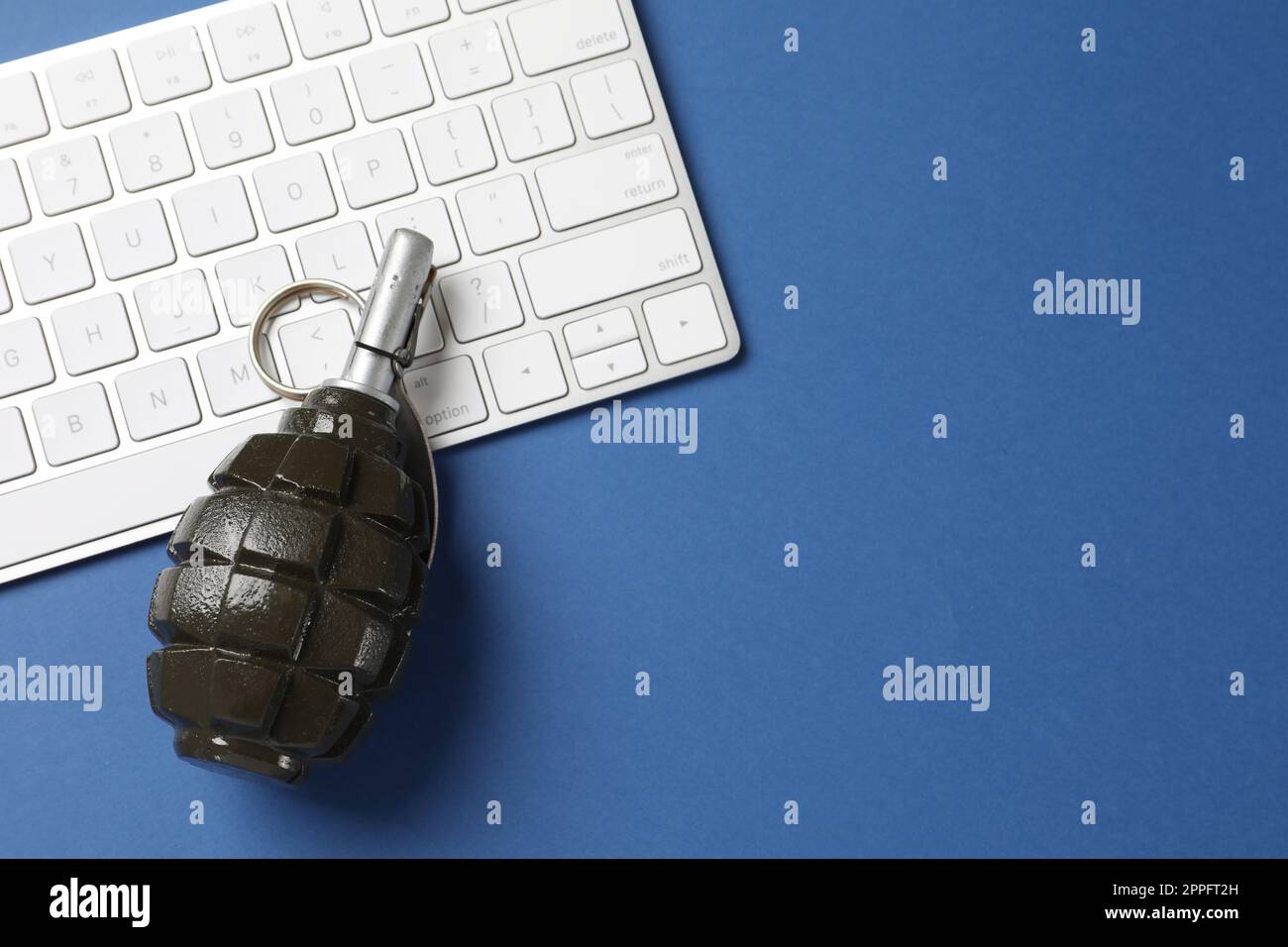 Grenade and computer keyboard on blue background, flat lay with space ...