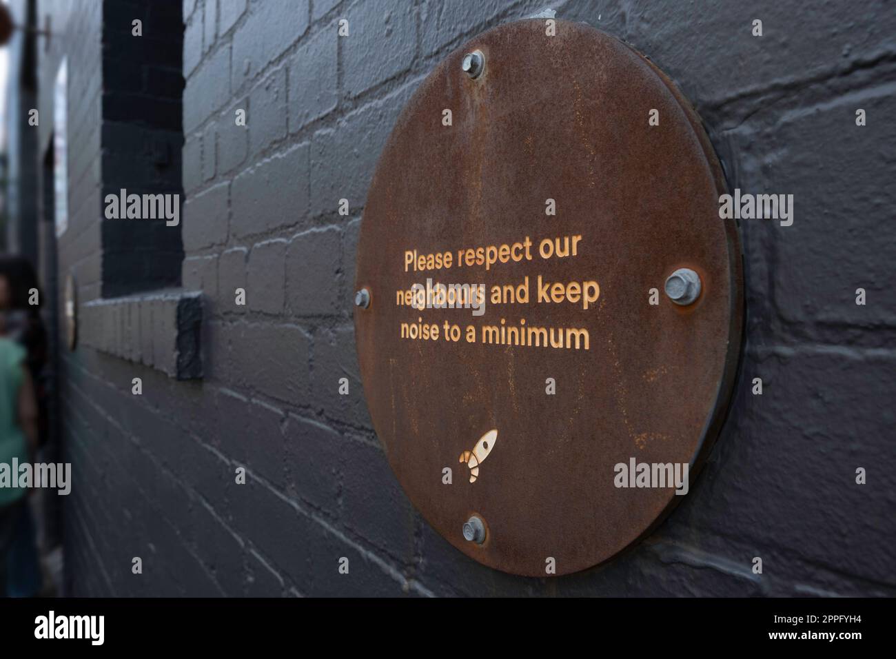 Sign with logo "Please respect our neighbors and keep noise to a ...