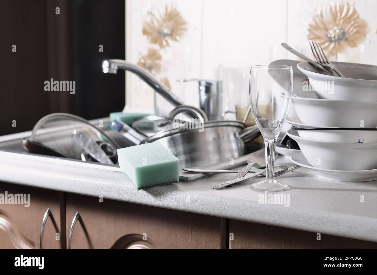 A huge pile of unwashed dishes in the kitchen sink and on the ...