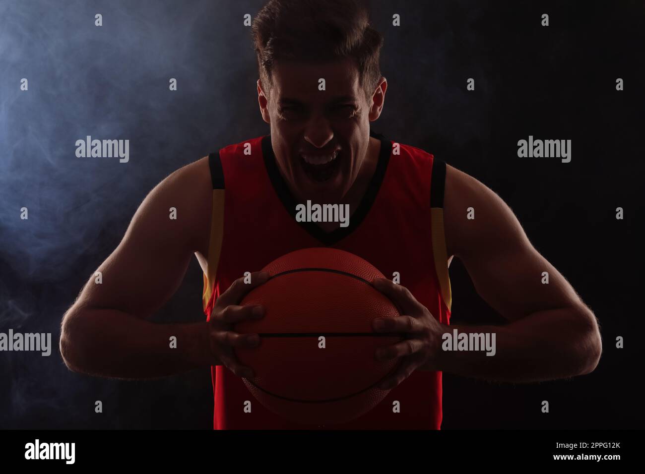 Basketball player with ball on black background Stock Photo - Alamy