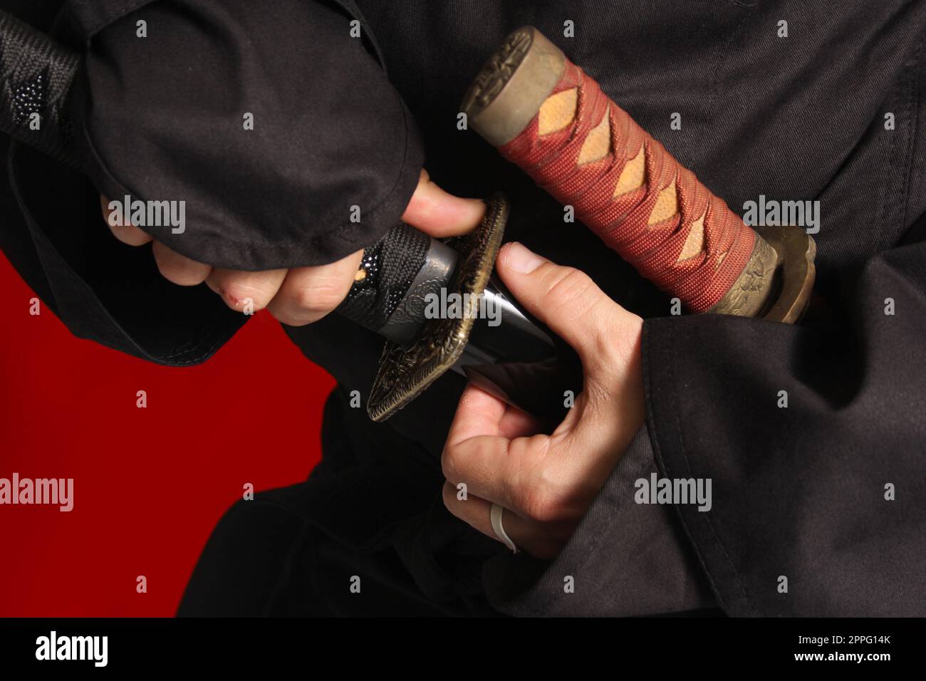 Man Removing Japanese Katana Blade From Scabbard Stock Photo - Alamy