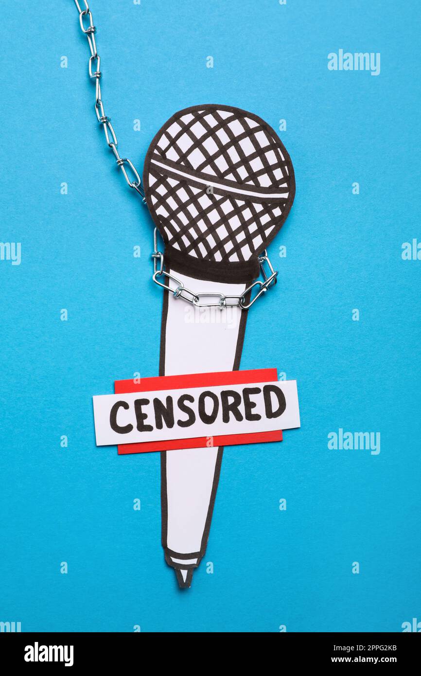 Card with word Censored, paper microphone and chain on light blue ...