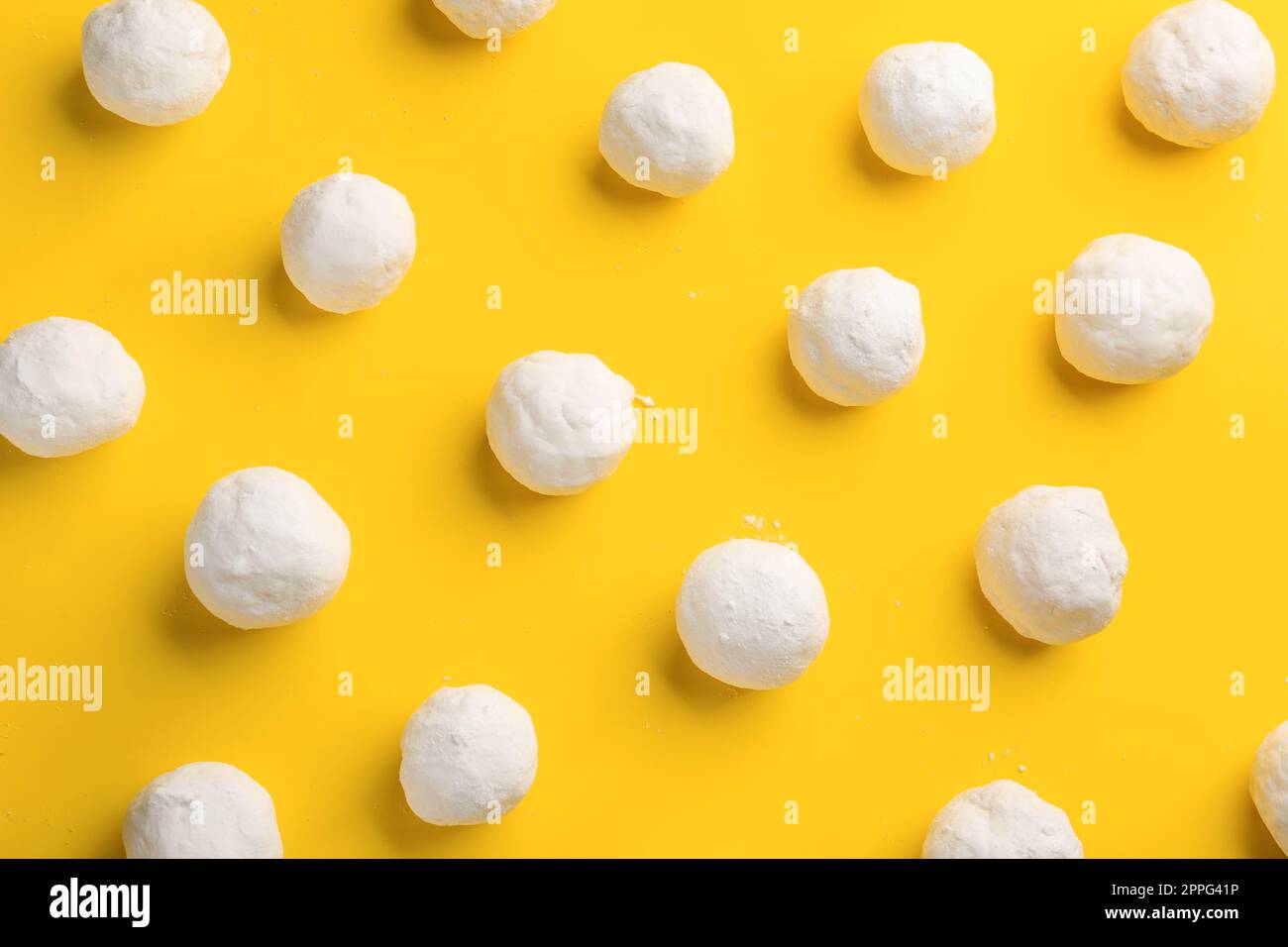 Round snowballs on yellow background, flat lay Stock Photo - Alamy