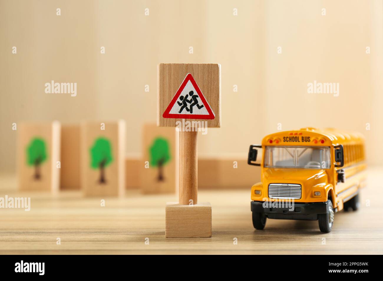 Traffic sign Attention children crossing street and toy bus on wooden ...