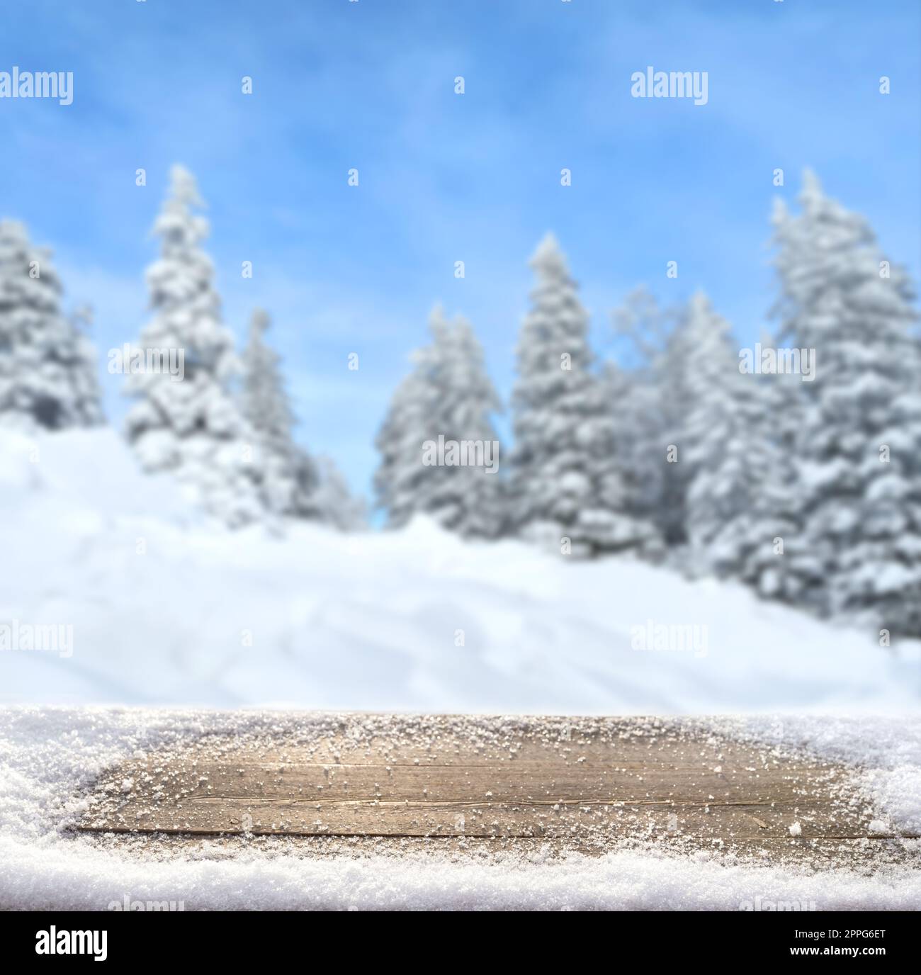 Wooden desk of free space and snow winter landscape with blurred fir ...