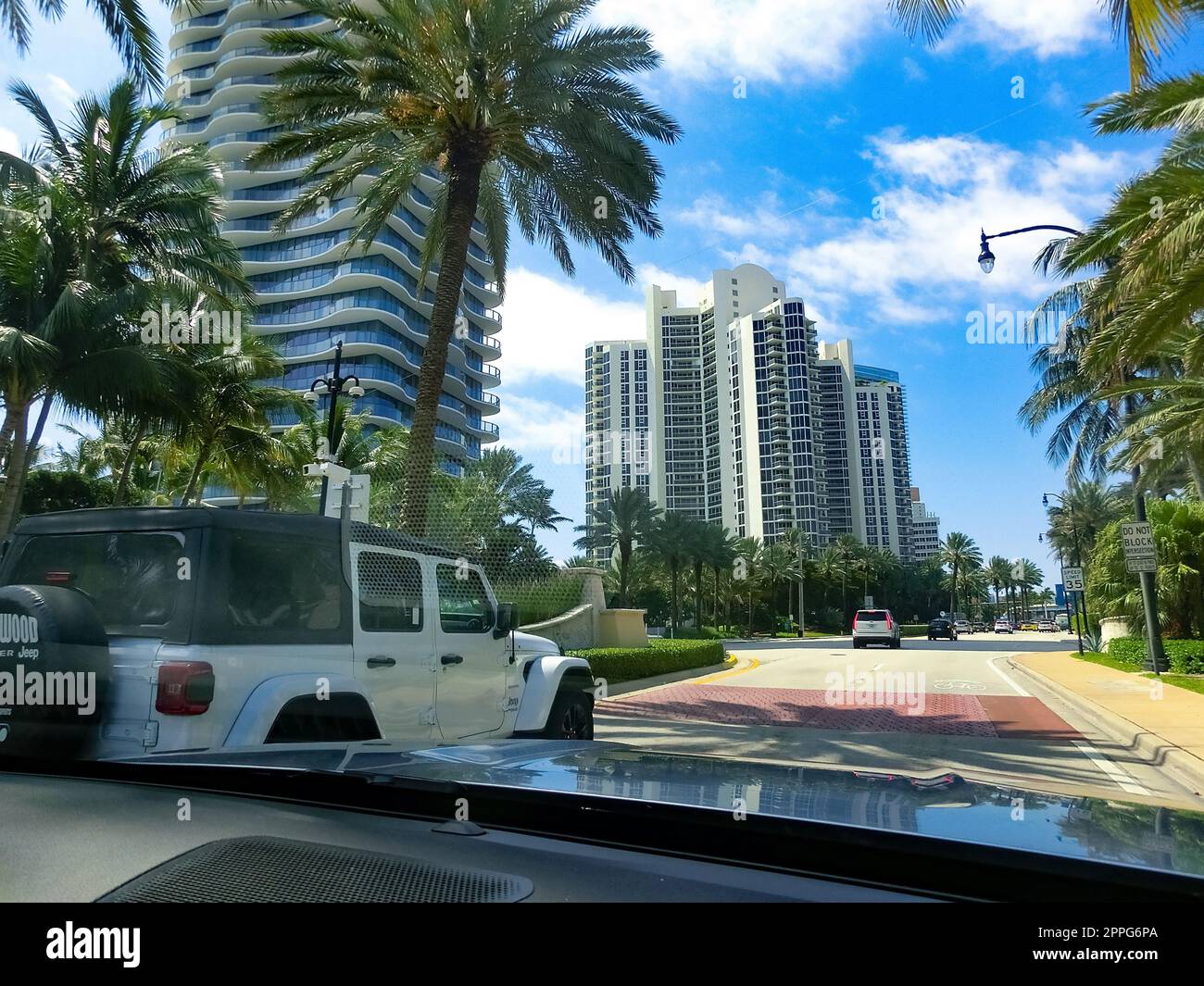 Modern apartment buildings with palm trees at Miami - view from road ...