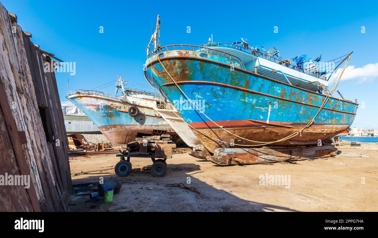 Old rusty ship under repairing on grungy dry dock in shipyard in old ...