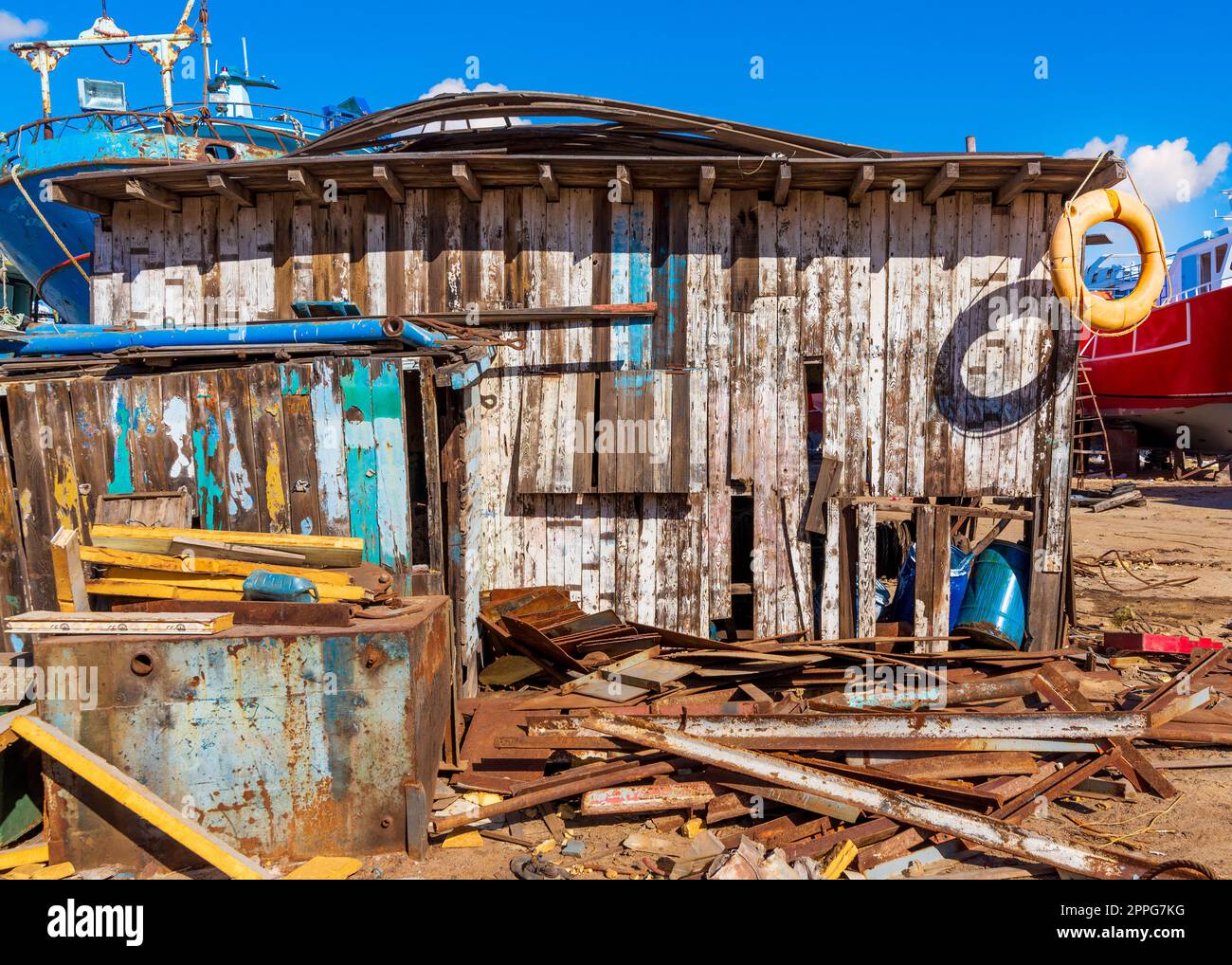 Shabby small building among lot of board with old orange life saver on ...