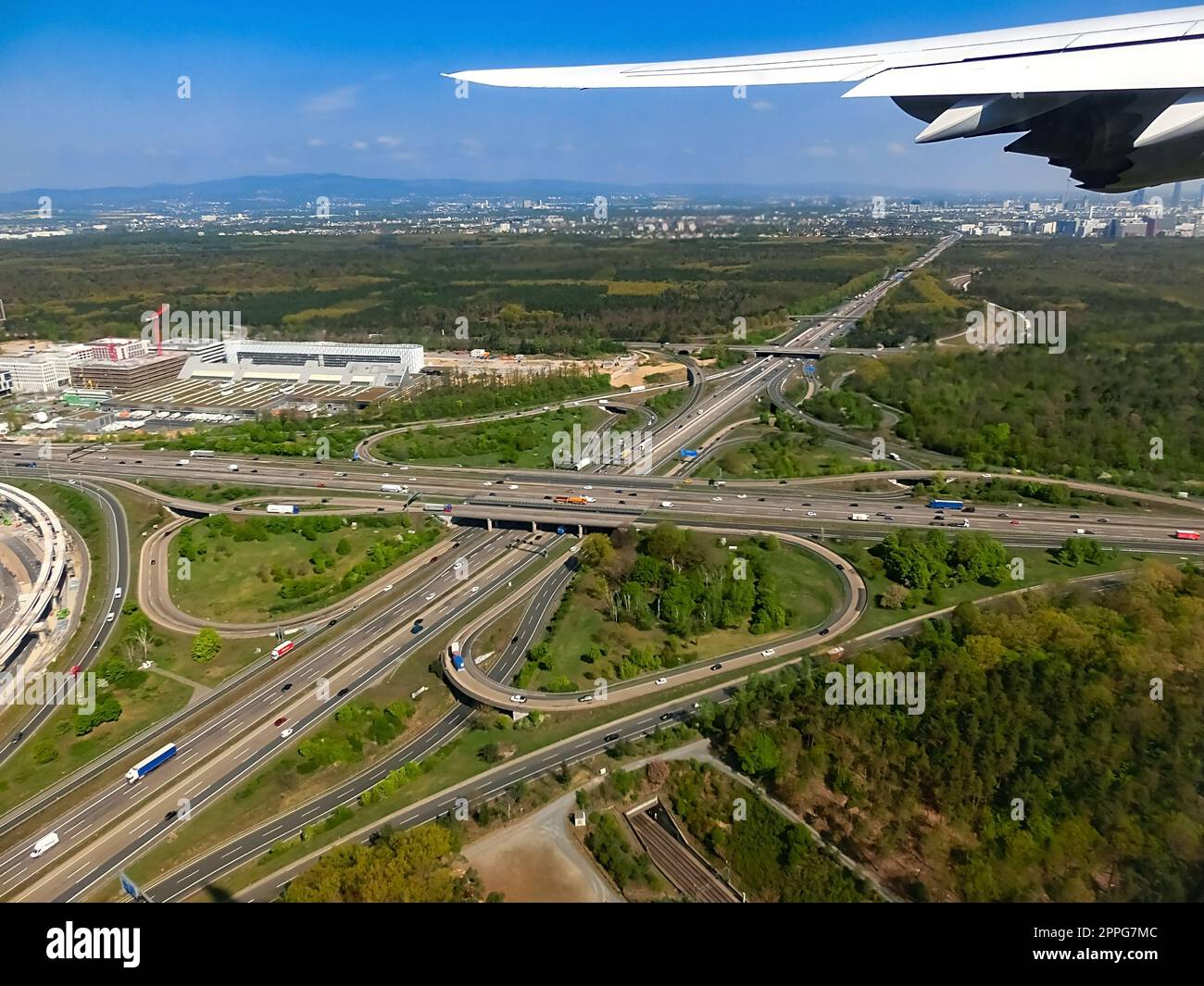 Airplane window view of wing, highway junctions and green forest Stock ...