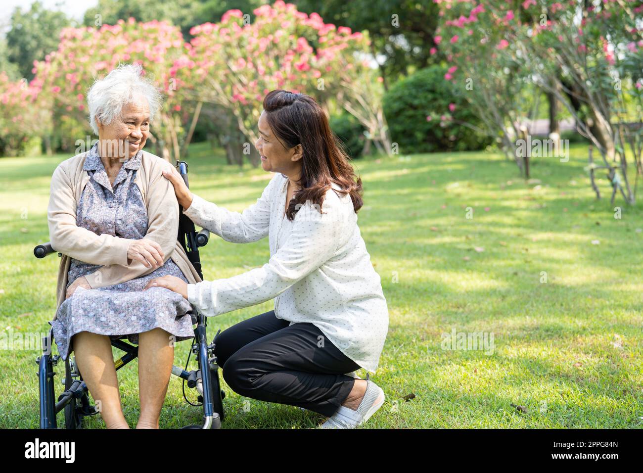 Caregiver help and care Asian senior or elderly old lady woman patient sitting and happy on ...