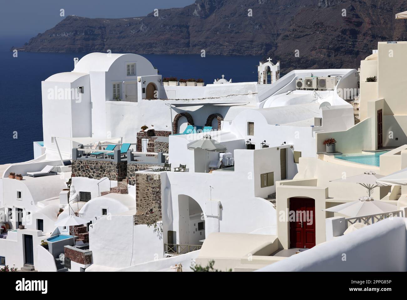 Whitewashed houses with terraces and pools and a beautiful view in Oia ...