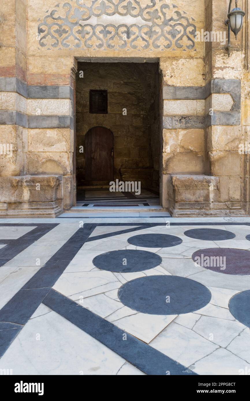 Stone bricks wall and opened door leading to passage at the courtyard ...