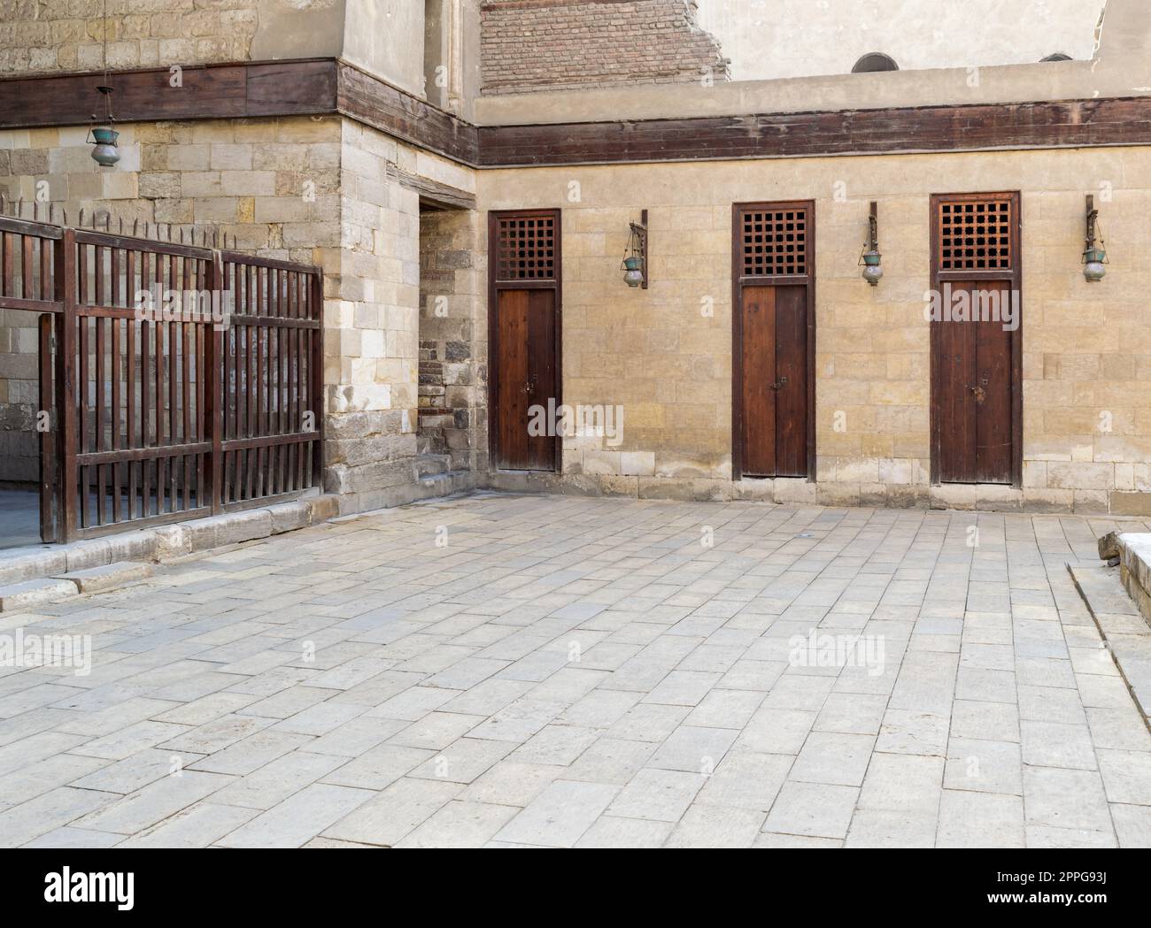 Three adjacent doors in a stone bricks wall and wooden fence, Sultan Al ...
