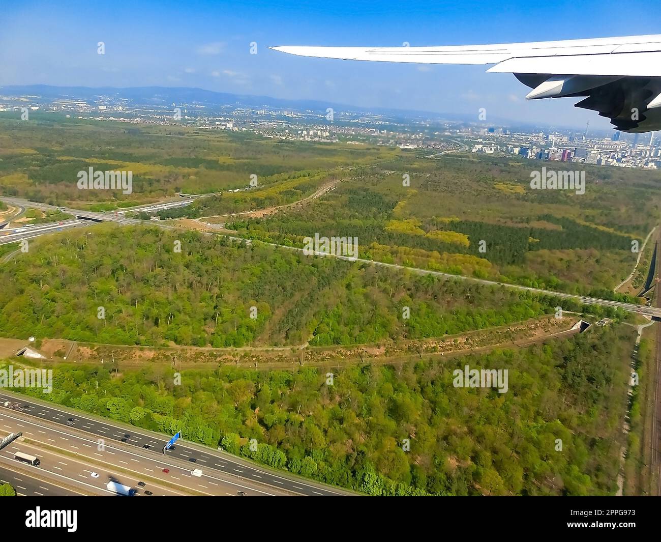 Airplane window view of wing, highway junctions and green forest Stock ...