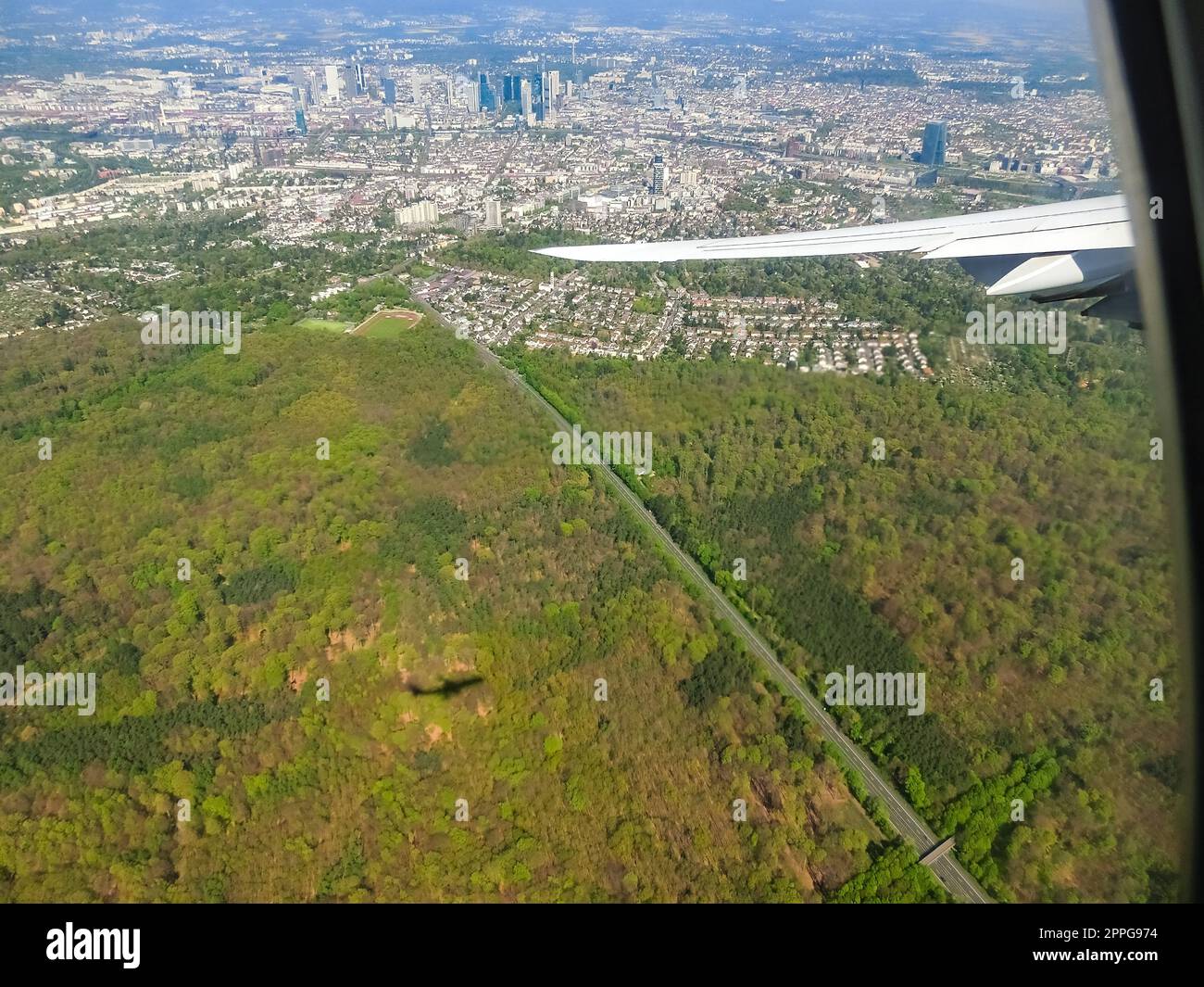 Airplane window view of wing, highway junctions and green forest Stock ...