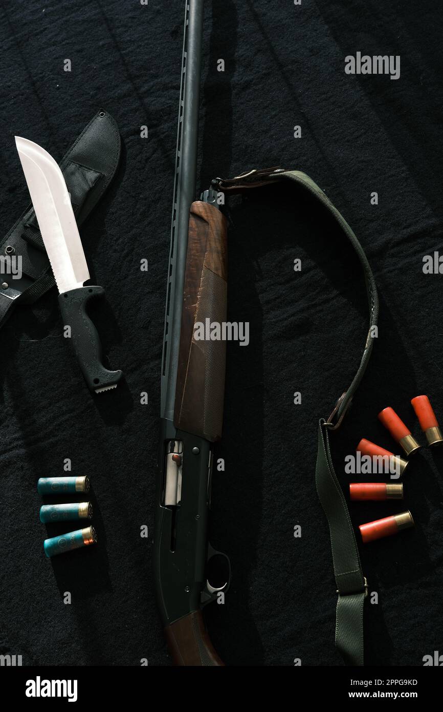 Weapon on black cloth: knife, rifle, shells,top view. Top view of knife ...