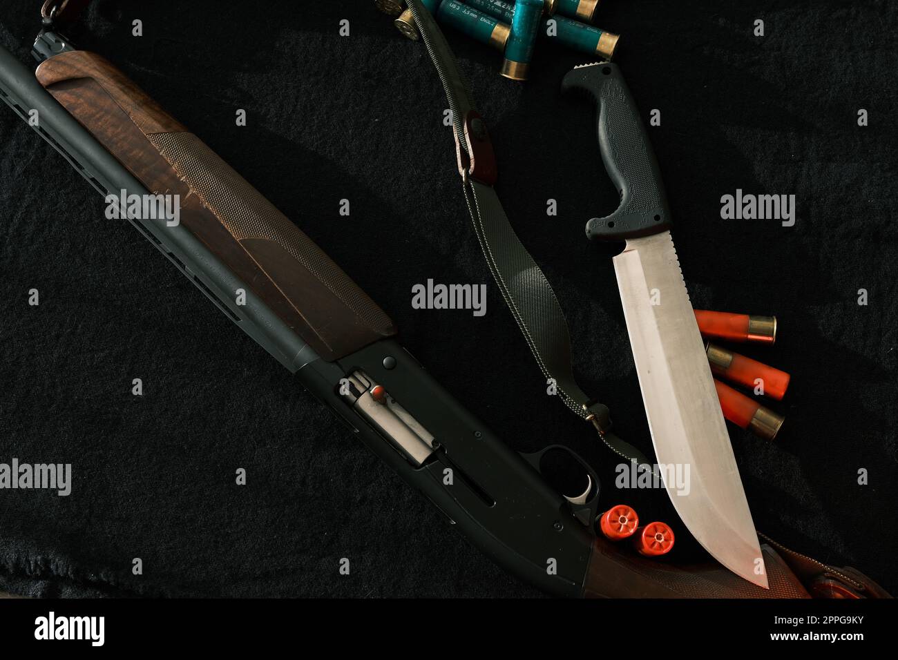 Weapon on black cloth: knife, rifle, shells,top view. Top view of knife ...