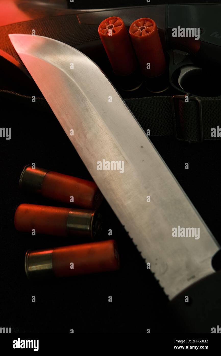 Weapon on black cloth: knife, rifle, shells,top view. Top view of knife ...