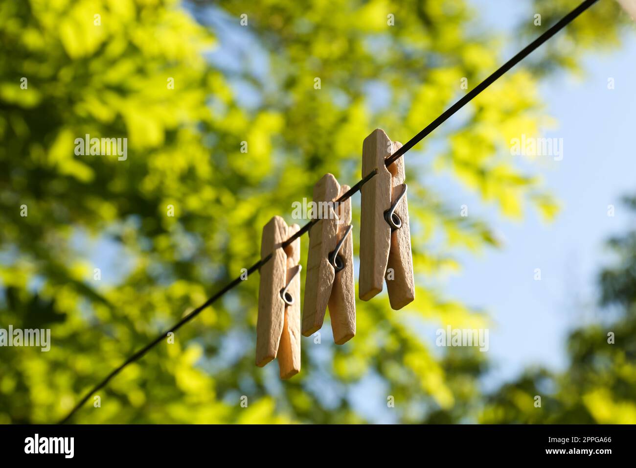 Wooden clothespins hanging on washing line outdoors Stock Photo - Alamy