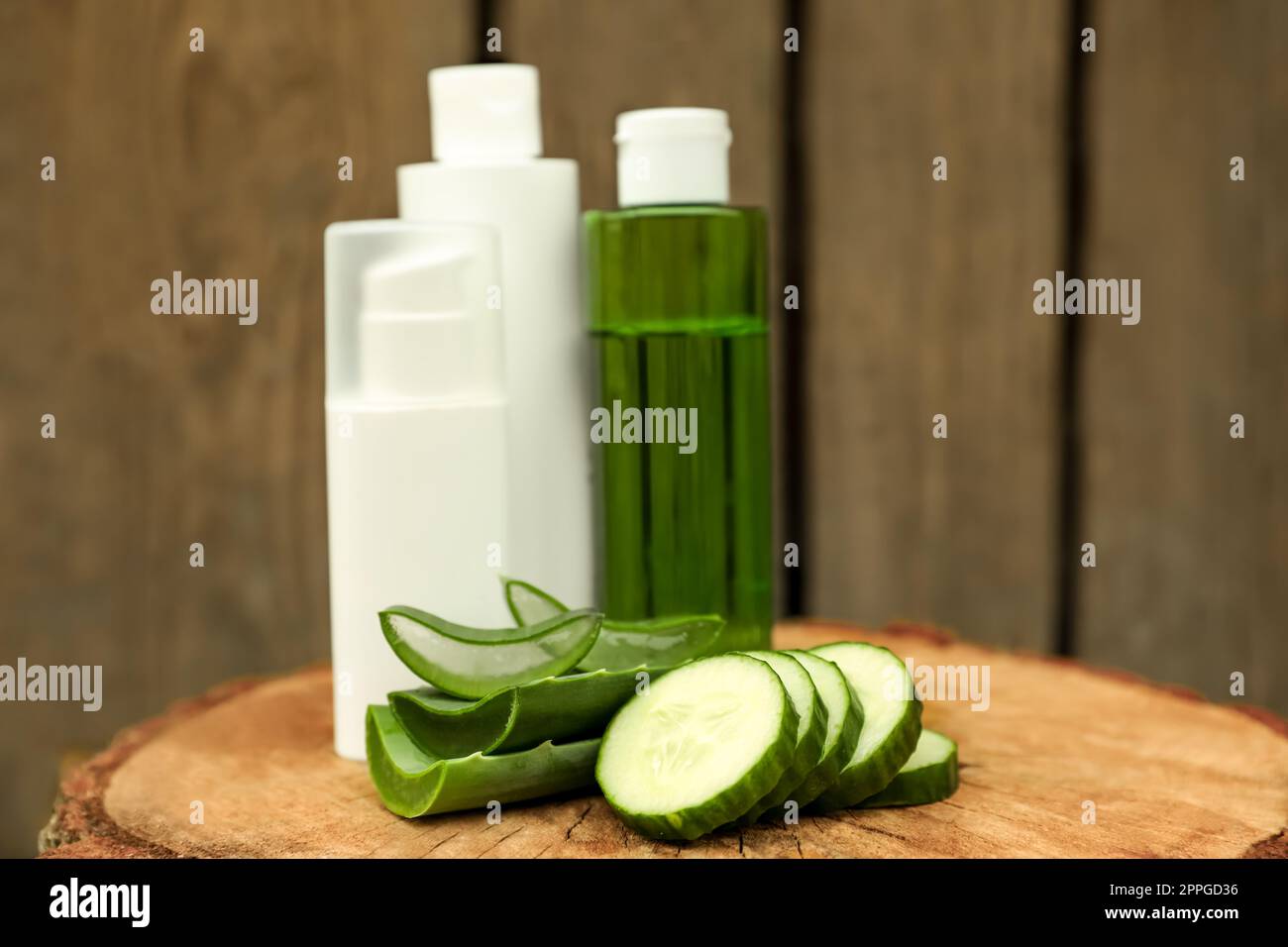 Bottles of cosmetic products, sliced aloe vera leaves and cucumber on ...