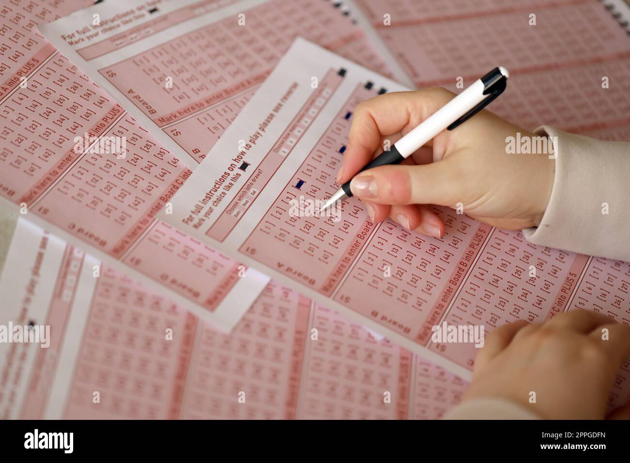 Filling out a lottery ticket. A young woman plays the lottery and ...