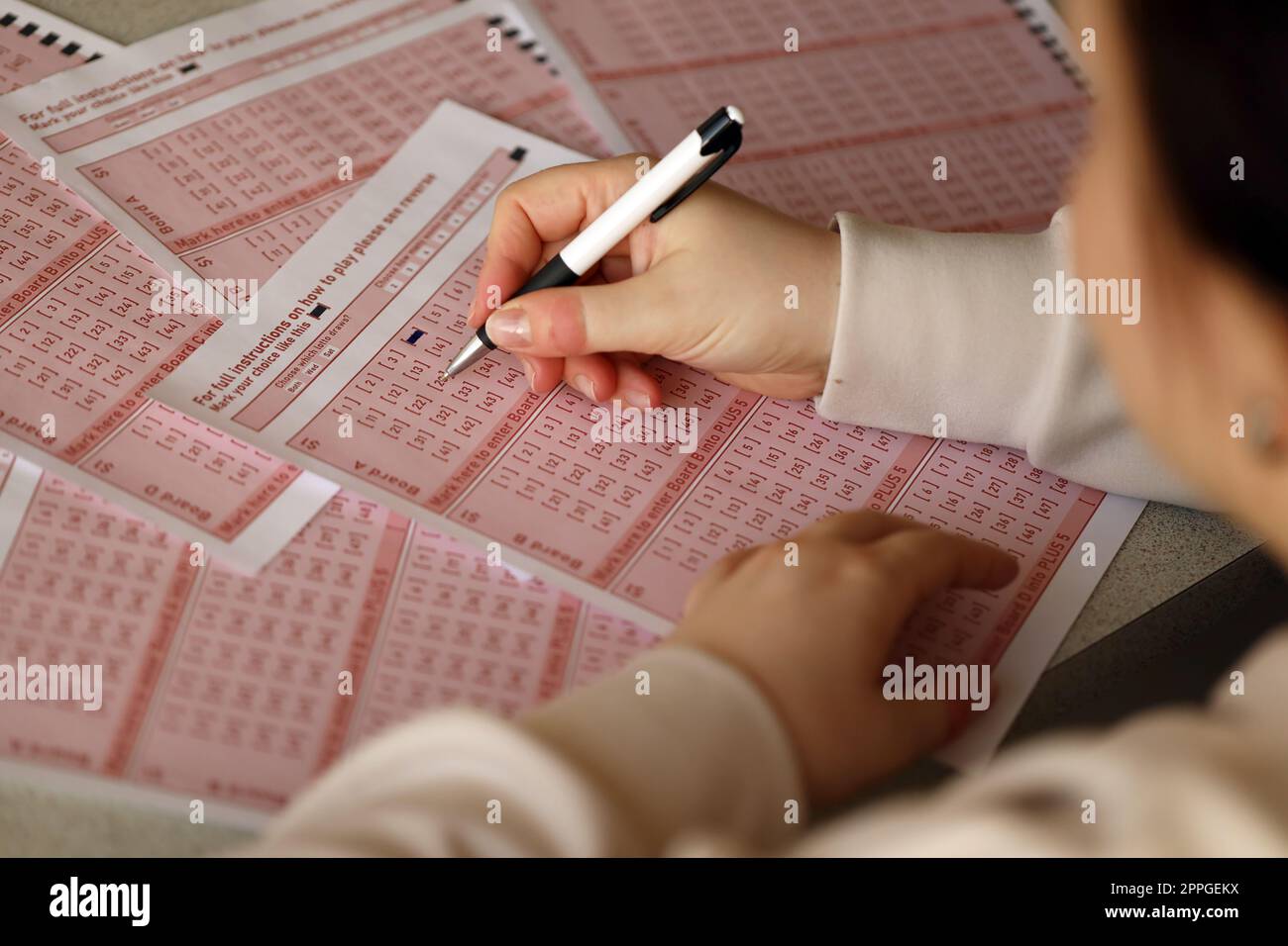 Filling out a lottery ticket. A young woman plays the lottery and ...