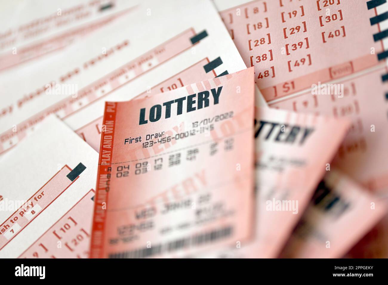Red lottery ticket lies on pink gambling sheets with numbers for ...
