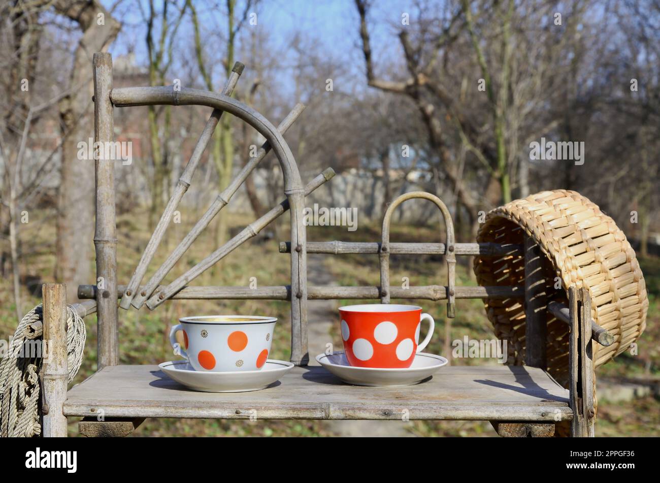 Rustic still life with a cups of tea and straw hat Stock Photo - Alamy