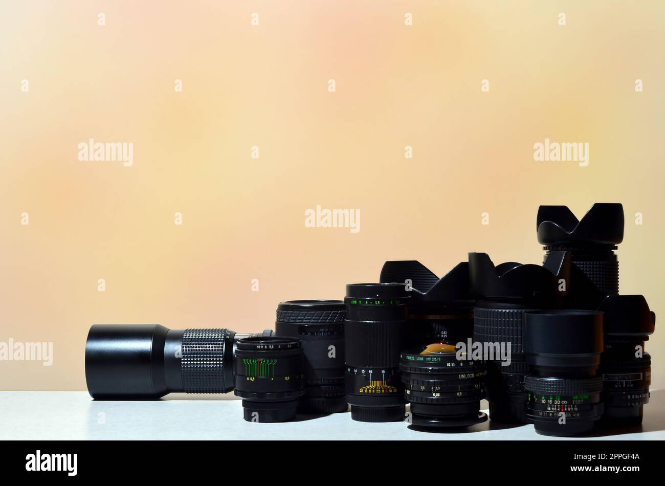 Many different professional lenses for SLR camera lies on a colorless ...