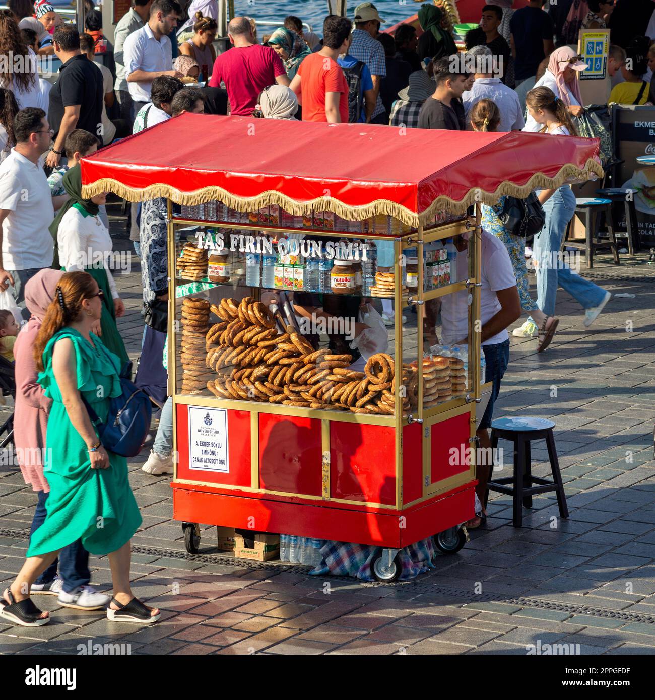 Male peddler selling simit on traditional Turkish fast food cart at ...