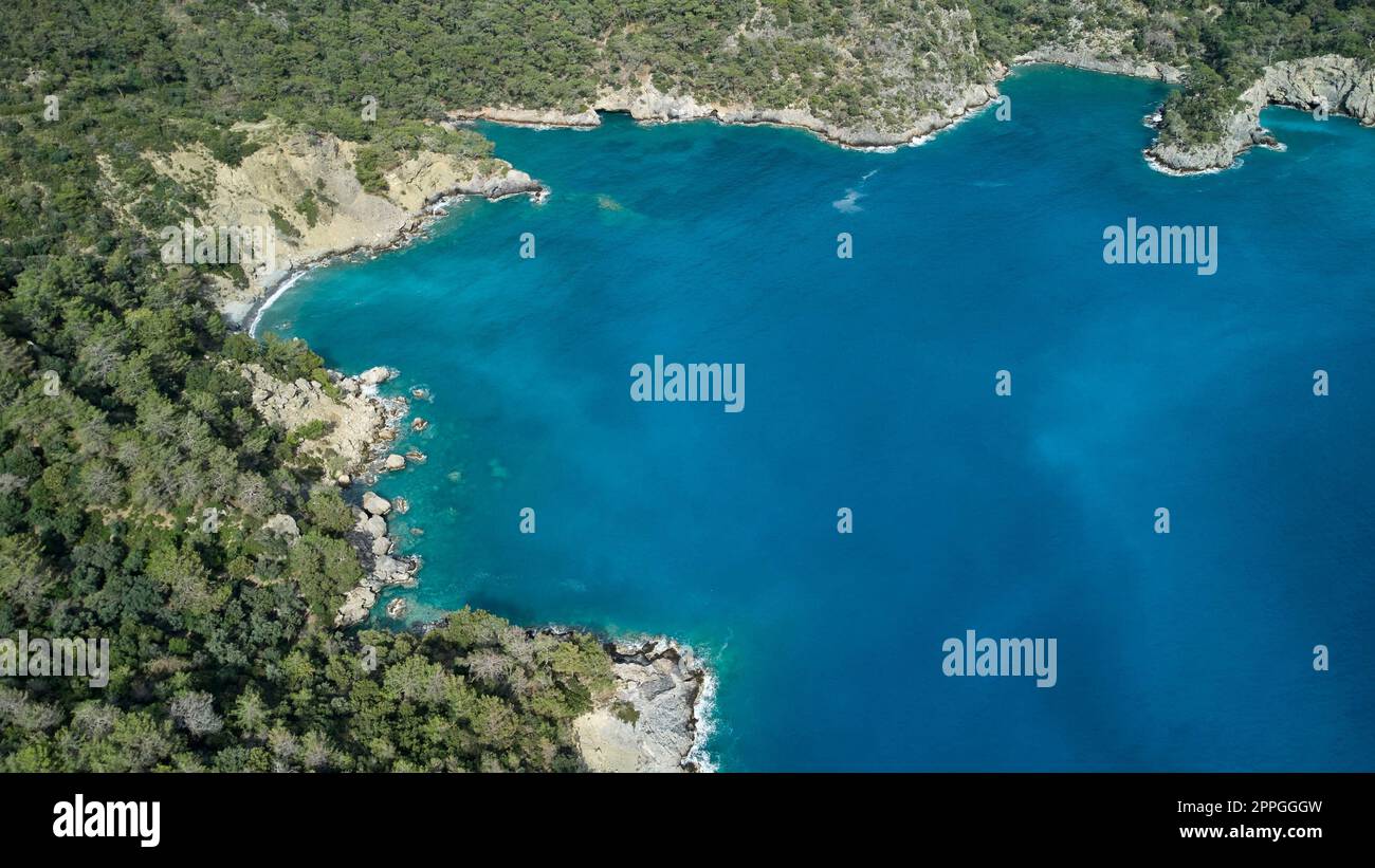 An aerial view of the shoreline featuring a pristine blue body of water ...