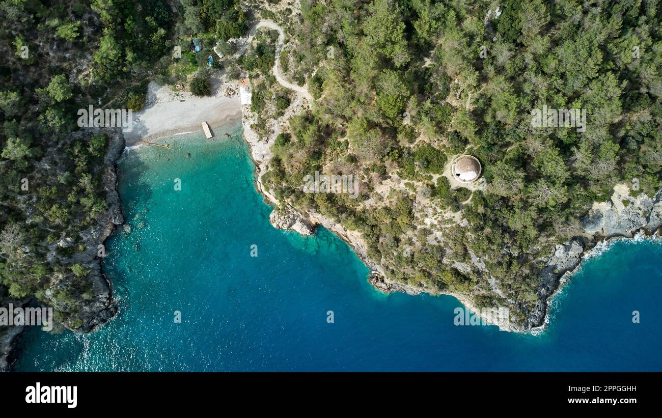 An aerial view of the shoreline featuring a pristine blue body of water ...