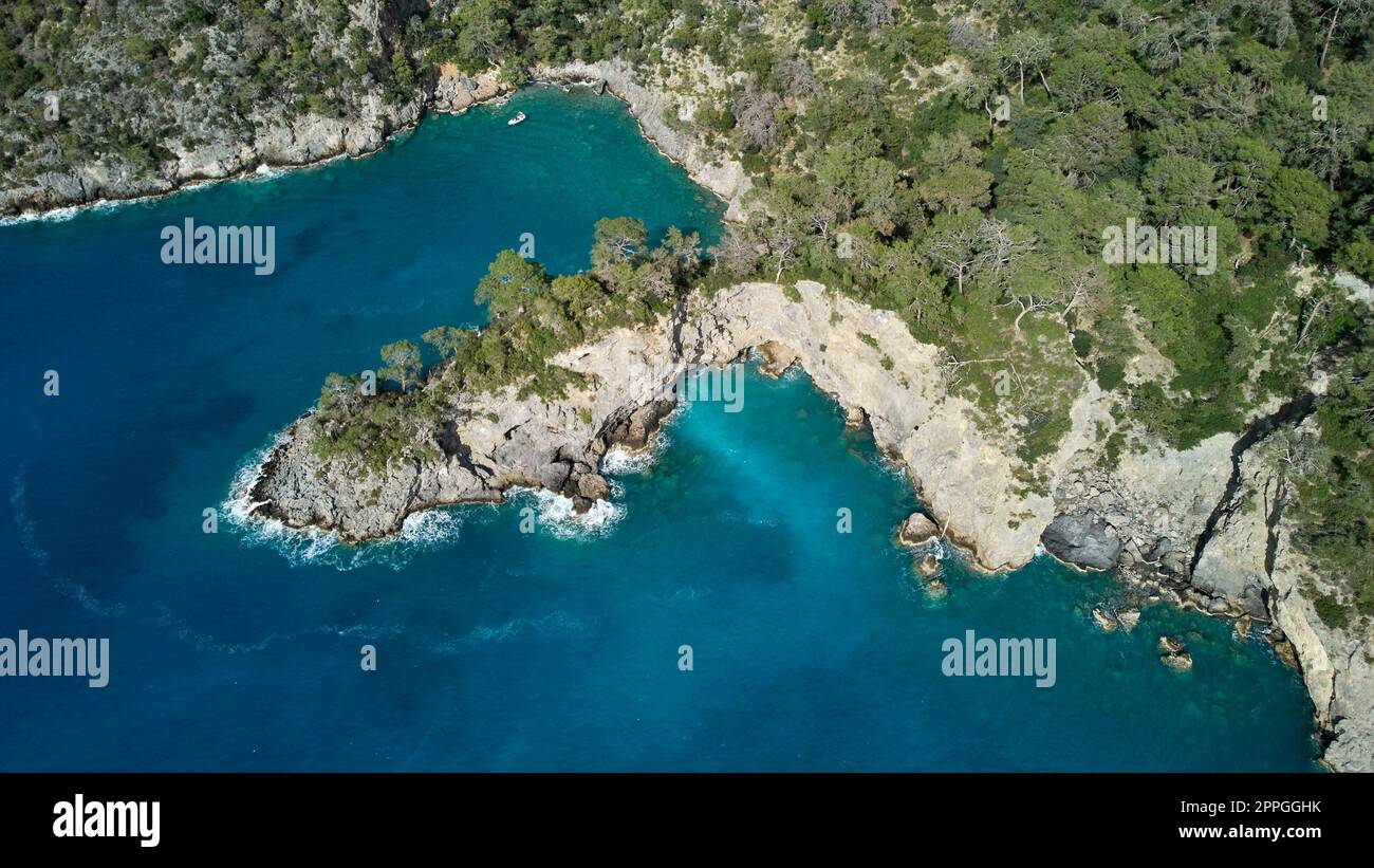 An aerial view of the shoreline featuring a pristine blue body of water ...