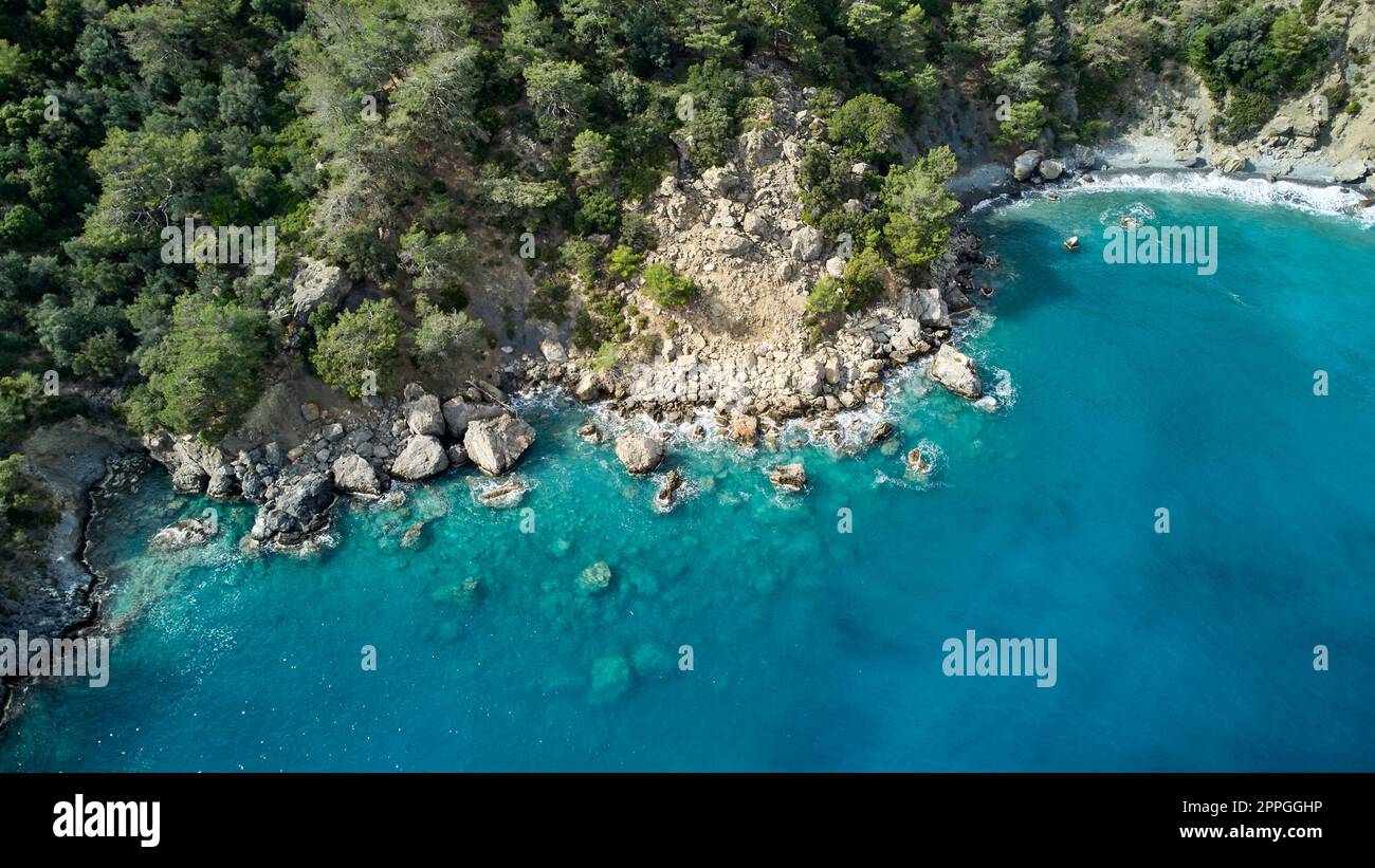 An aerial view of the shoreline featuring a pristine blue body of water ...