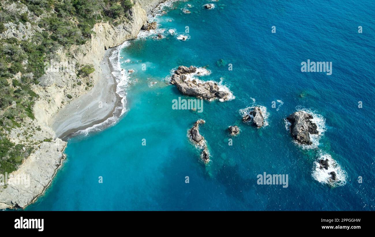 An aerial view of the shoreline featuring a pristine blue body of water ...