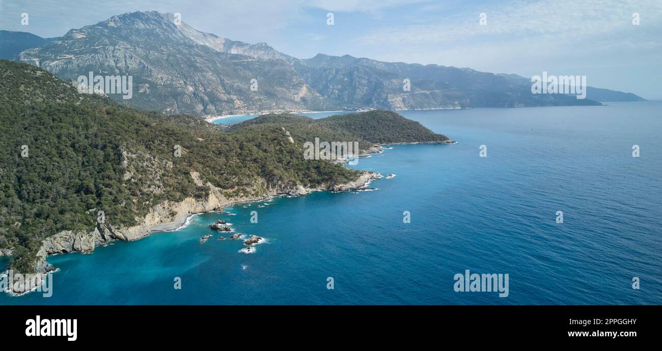 An aerial view of the shoreline featuring a pristine blue body of water ...