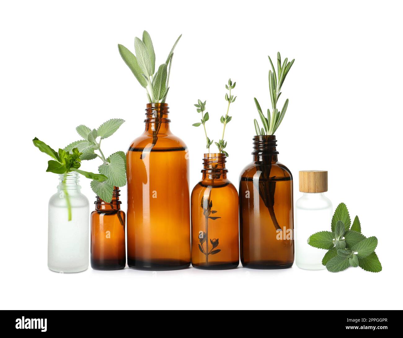Set with bottles of different essential oils and leaves on white ...