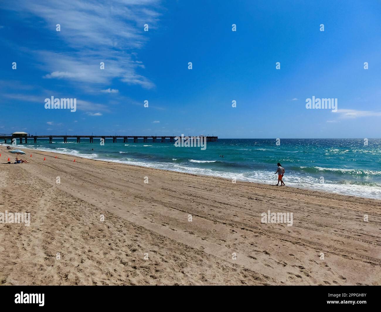 Long distance view of the sunny and tropical blue water shoreline with ...