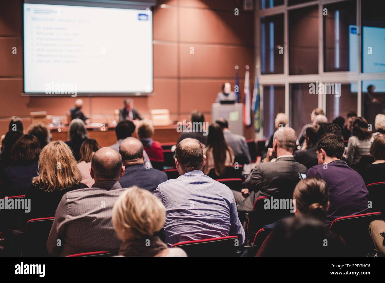 Audience in lecture hall participating at business event Stock Photo ...