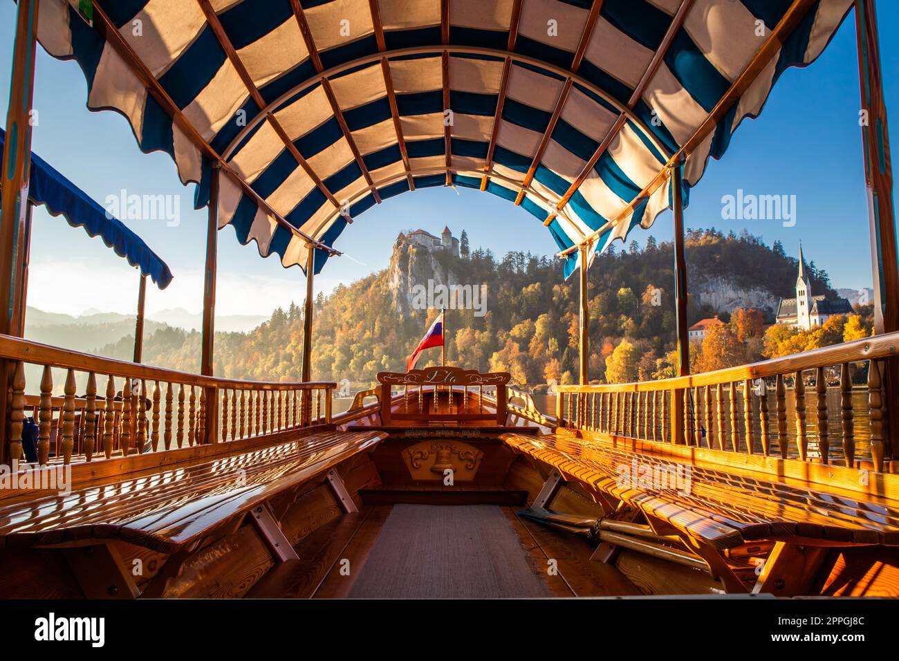 Interior of traditional pletna boat on lake Bled with old castle on the ...