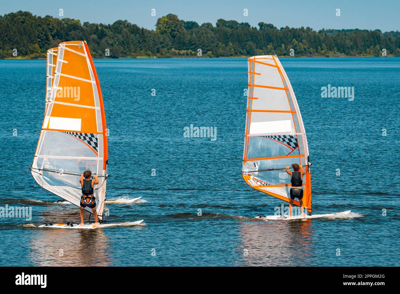 Group of surfers sailing along the lake water Stock Photo - Alamy