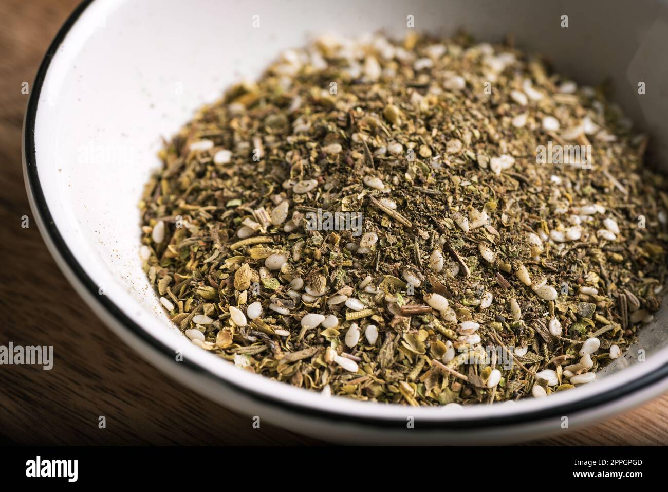 Mixed zaatar or zatar spices in white bowl close up. Oriental herbal ...