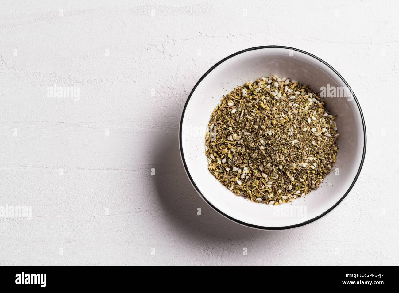 Mixed zaatar or zatar spices in white bowl on white background, copy ...