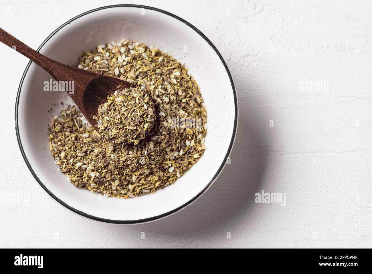Mixed zaatar or zatar spices in white bowl on white background, copy ...