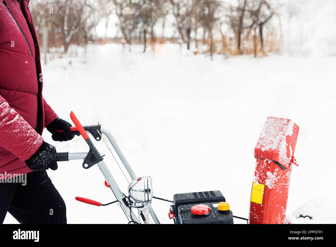 Man using red snowblower machine outdoor. Removing snow near house from yard Stock Photo - Alamy