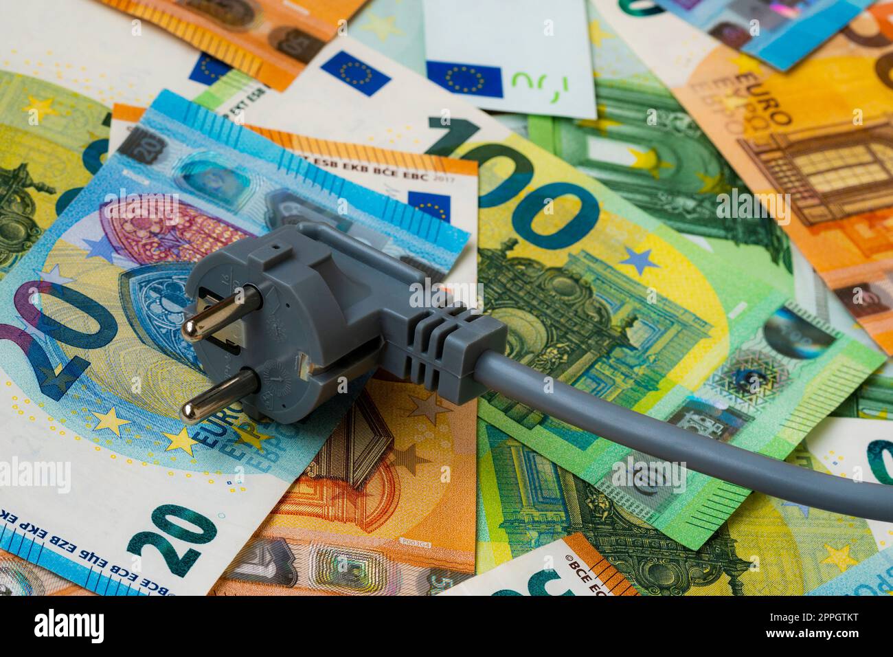 Grey electric plug on euro banknotes Stock Photo - Alamy