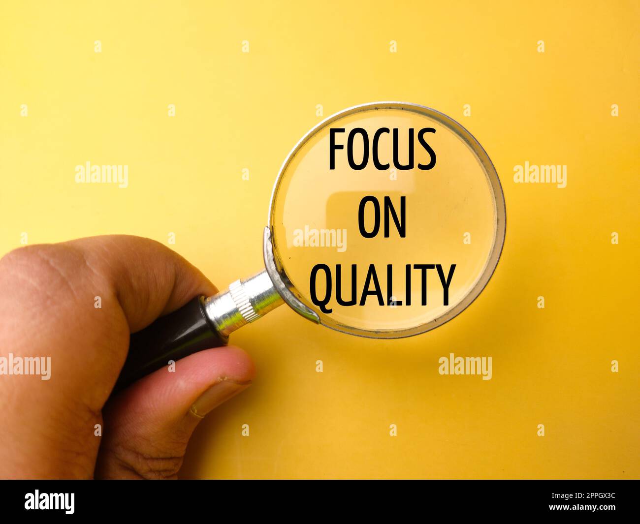 Hand holding magnifying glass with the word FOCUS ON QUALITY on a ...