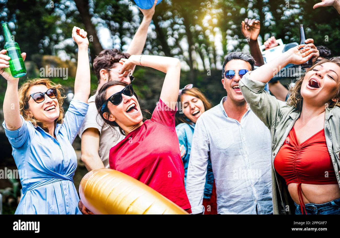 Happy mixed age people having fun out side cheering and dancing at ...